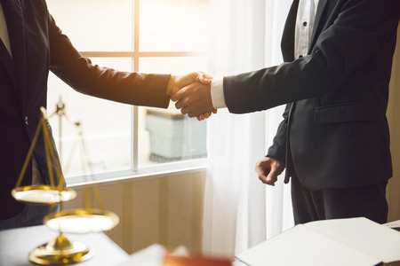 Handshake between attorneys and clients after agreeing to enter into a ...