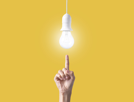 Business hand point light bulb on yellow background. concept of new ...