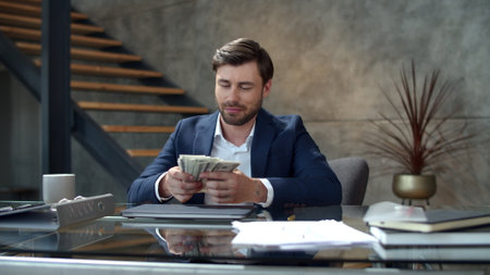 Portrait of smiling business man counting money at workplace in slow ...