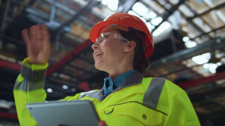Joyful woman supervisor smiling at huge digital modern production ...
