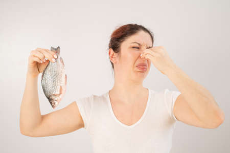 Caucasian woman opposes the disgusting smell of fish. A metaphor for ...