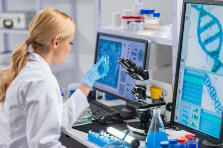 Professional female scientist is working on a vaccine in a modern ...