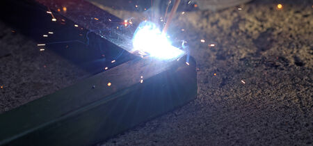 Iron welding with bright light and smoke at manufacturing - Stock Image ...