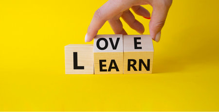 love and learn symbol. Businessman hand turns wooden cubes and changes ...
