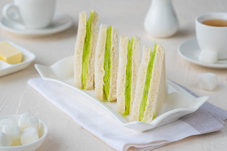 Tea triangular sandwiches with butter and fresh cucumber slices on a ...