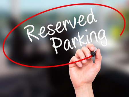 Man Hand writing Reserved Parking with black marker on visual screen ...