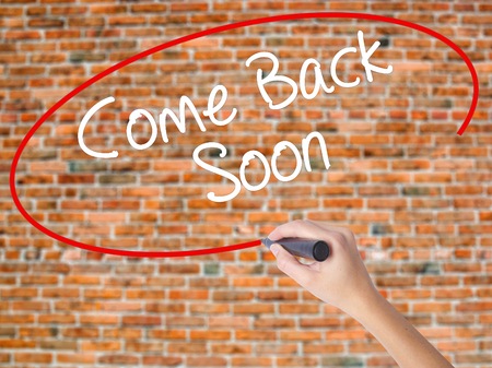 Woman Hand Writing Come Back Soon with black marker on visual screen ...