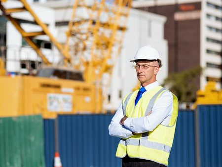 Engineer builder wearing safety vest at construction site - Stock Image ...