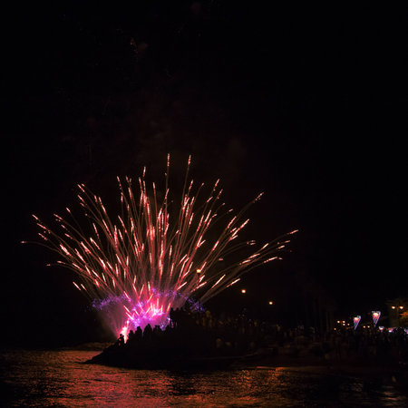 Colorful red fireworks in the night sky on the sea - Stock Image ...