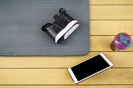 Virtual Reality or VR goggles left on the yoga exercise mat and tablet ...