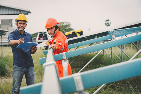engineer in solar power plant working on installing solar panel ...