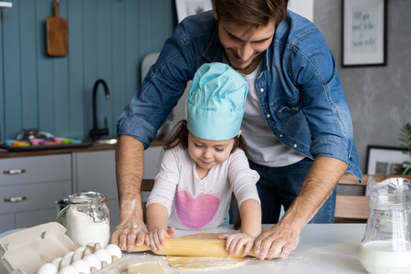 Daddy with daughter baking cake together in home kitchen. - Stock Image ...