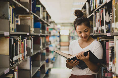 Young Asian women are searching for books and reading books on the ...