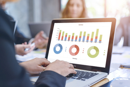 business women create charts and graphs in laptop at the office ...