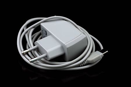 Gray cell phone charger on shiny black surfaceの写真素材 [40003147557] - イメージマート