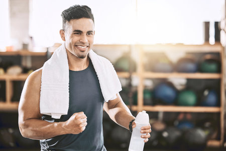 Happy trainer cheering in the gym. Fit, strong man taking a break from ...