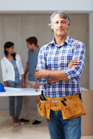 Confident male contractor with clients n background. Portrait of ...