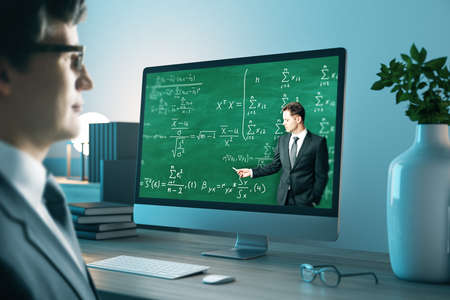 Young business man at office desk looking at computer screen with ...