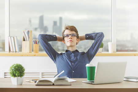 Portrait of relaxed businessman working on project at modern desk with ...