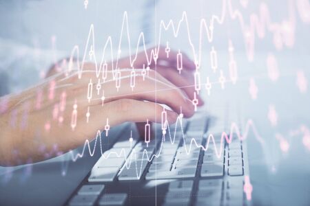 Multi exposure of graph with man typing on computer in office on ...