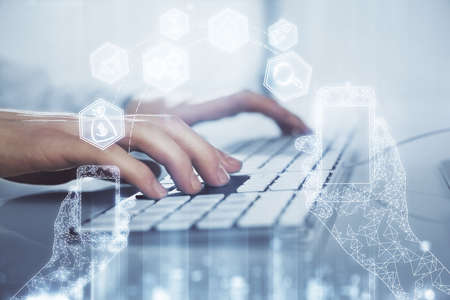 Technology theme hologram with man working on computer on background ...