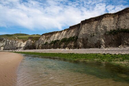 White cliffs and sand beach on the sea shore. The coastline of Franceの ...