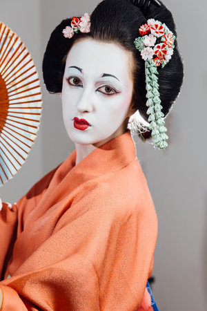 Woman in geisha makeup and a traditional Japanese kimono. Studio ...