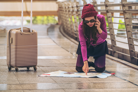 Lost woman traveller making phone call asking for help while looking at ...