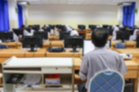 Student with teacher and desktop computer. Abstract Blur blurred ...