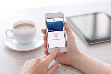 Women hands holding white phone with debit card app touch pay on screen ...