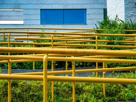 View on a rusty yellow railing of a sidewalk on a sunny day.の写真素材 ...