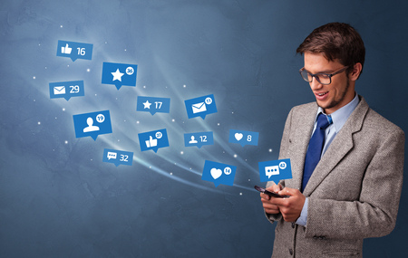 Young person using phone with flying social media icons around - Stock ...