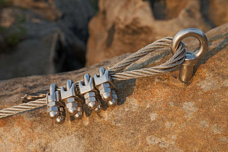 Solid knot on steel rope. Iron twisted rope fixed in block by strong ...