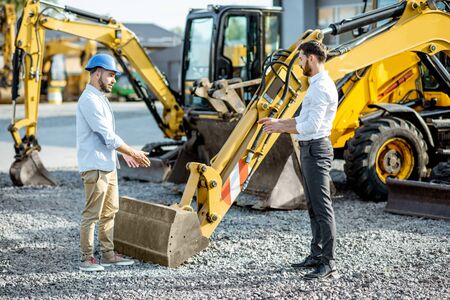 Builder choosing heavy machinery for construction with a sales ...