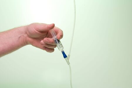 A hospital worker using a saline flush in an IV tube. - Stock Image ...