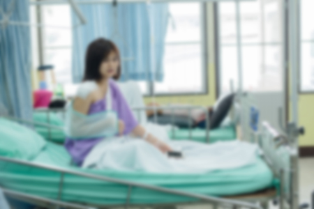Broken arm patient with arm sling for treatment in the hospital blurred ...
