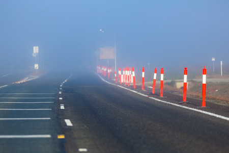 Orange lane markers in a construction road works zone along a road in ...