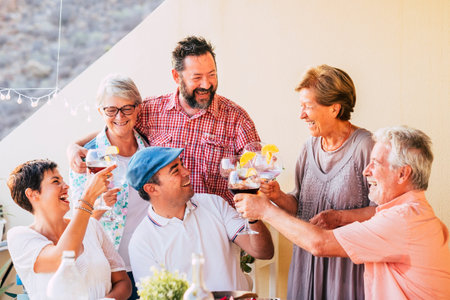 Group of different ages and generations have fun together toasting and ...