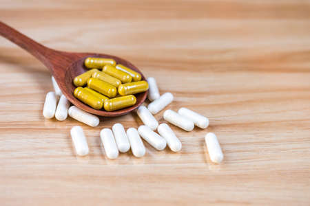 Herbal supplement in wooden spoon, Turmeric powder and probiotic powder ...