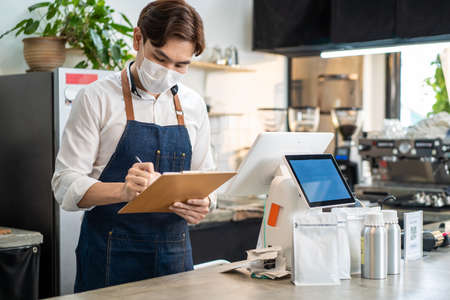 Asian cafe business male owner checking takeaway order from clipboard ...