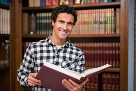 Handsome smiling man reading a book Images - Search Images on Everypixel