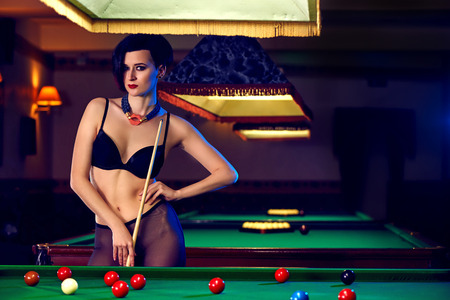 Hot sexy young woman at billiards club playing snooker FY31055685706