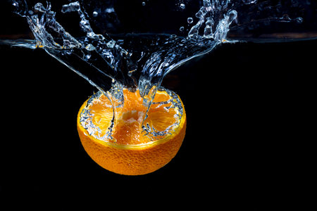 Orange with frozen water splash and drops on the black background ...