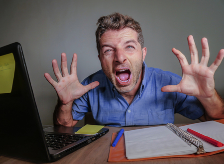 young crazy stressed and overwhelmed man working messy and screaming ...