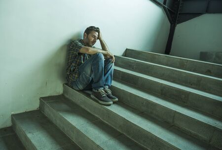 dramatic lifestyle portrait of young depressed and sad man sitting ...