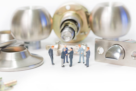Selective focus of miniature businessman handshake and stainless steel ...