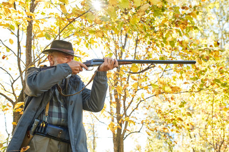 Concentrated hunter holding rifle and waiting for prey, hunter shooting ...