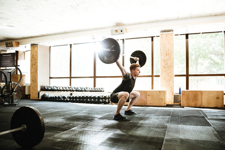 Photo of caucasian sports strong man make sport exercise with barbell ...