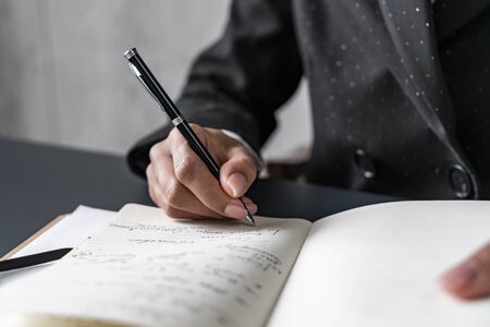 Close up of African American businesswoman hand writing in notebook and ...