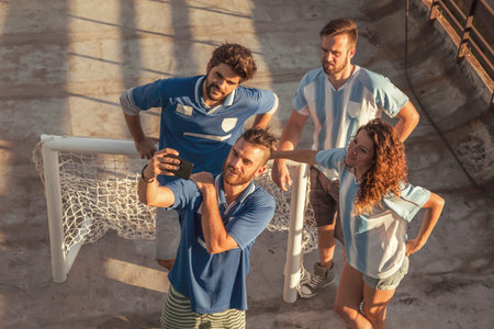 Group of young friends having fun playing football on a building ...